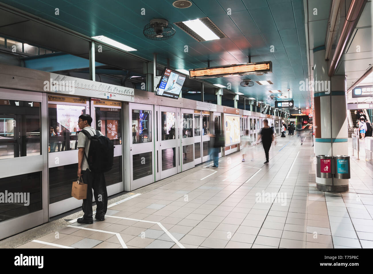 Taipei, Taiwan : People queue up and wait for a metro train at a metro ...