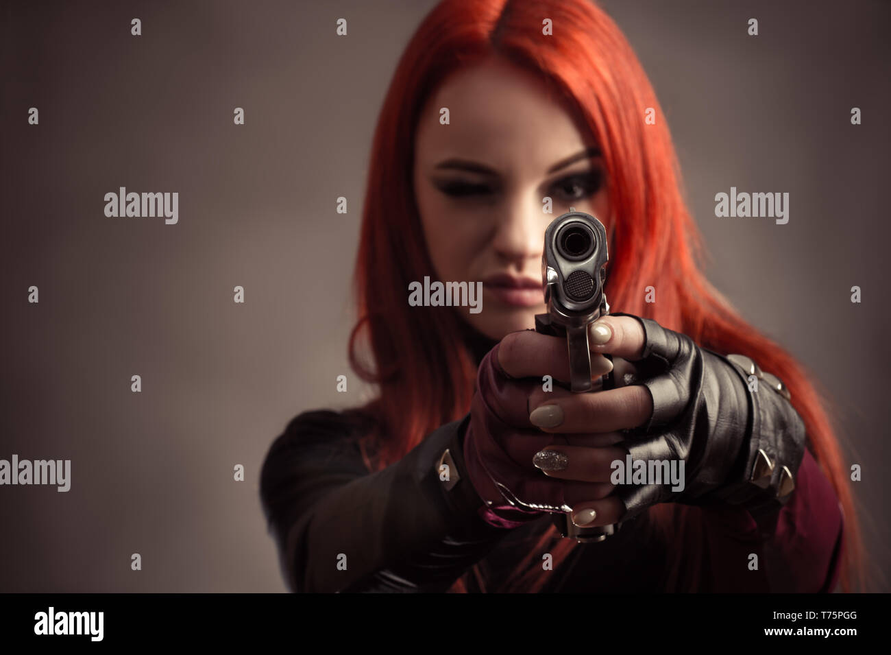 beautiful woman aim with pistol isolated on gray background Stock Photo ...