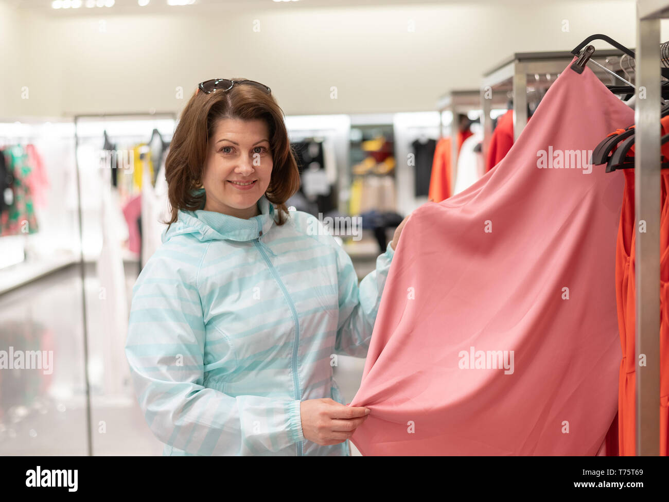 The Woman chooses clothes in the store Stock Photo - Alamy