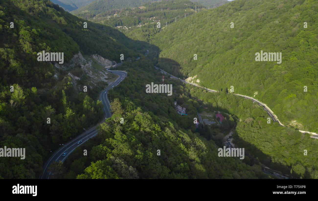 Aerial view over mountain road going through forest landscape, Winding ...