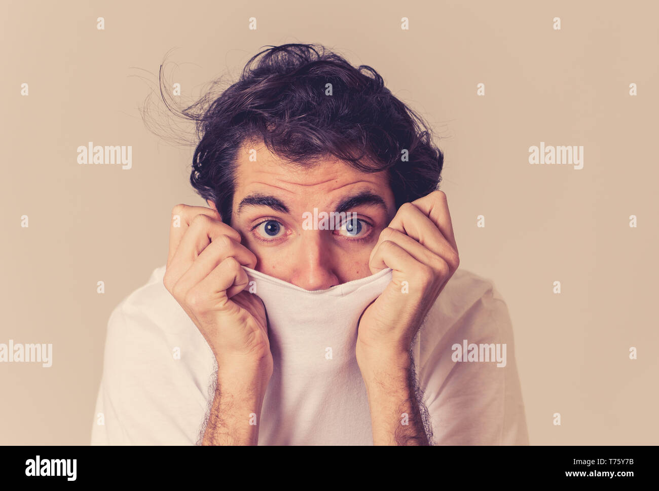 Young man feeling frightened and shocked making scared gestures in fear ...