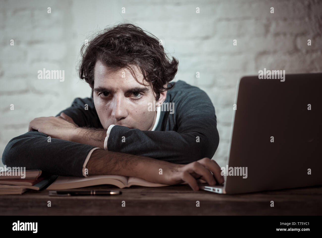 Young University student feeling tired and overwhelmed studying at ...