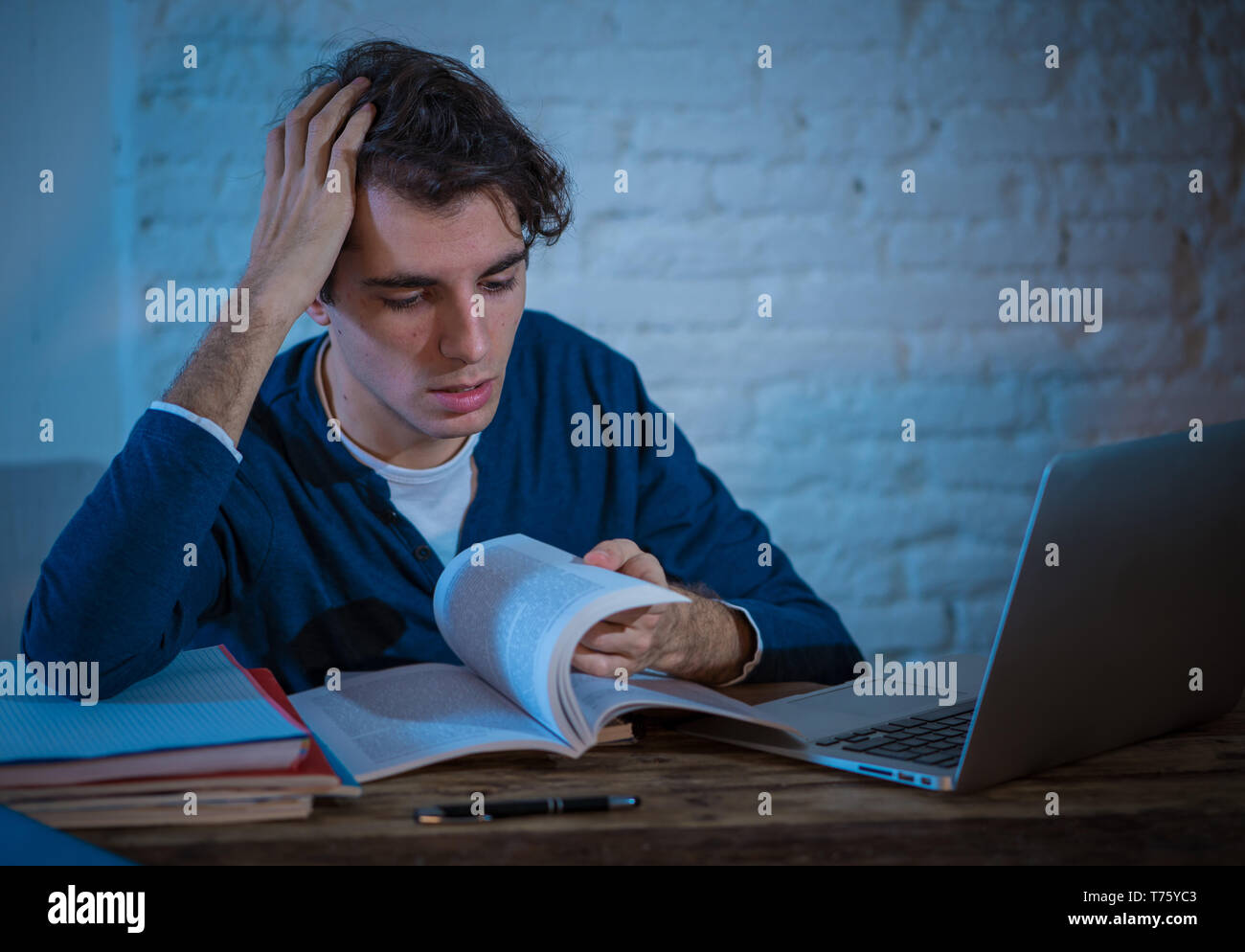 Young University student feeling tired and overwhelmed studying at ...