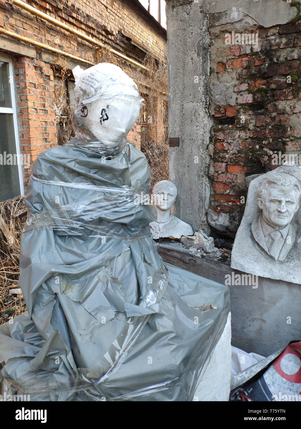Old abandoned sculptures in a neglected park entwined with plants ...
