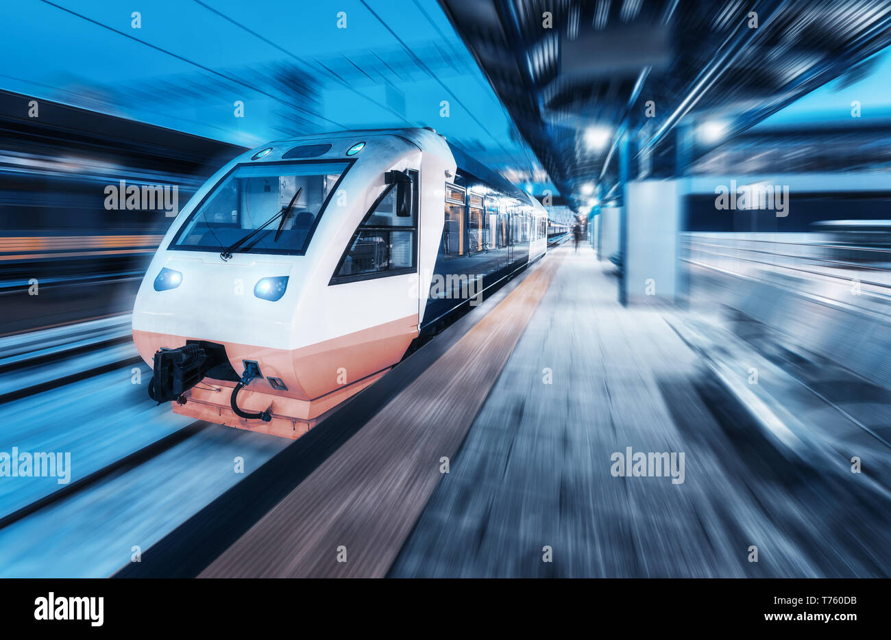 Moving train on the railway station at night with motion blur effect ...