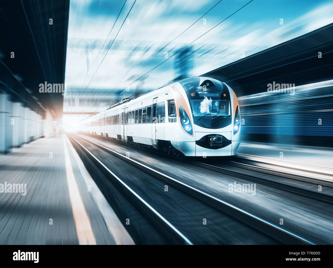 High speed train at the railway station at sunset in Europe. Modern ...