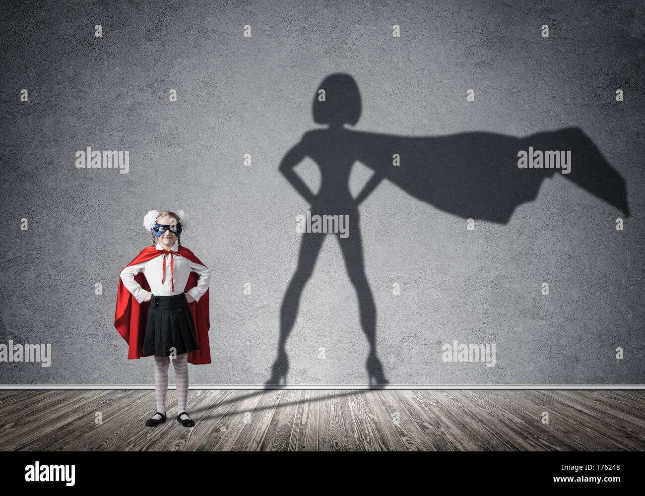 Girl power concept with cute kid guardian and shadow at wall. Mixed ...