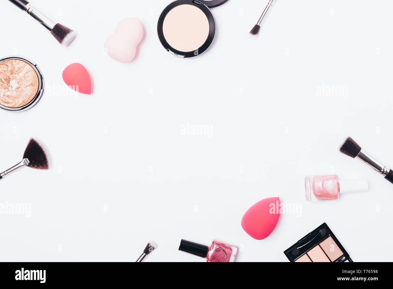 Makeup background of powders, sponges and brushes on white table with ...