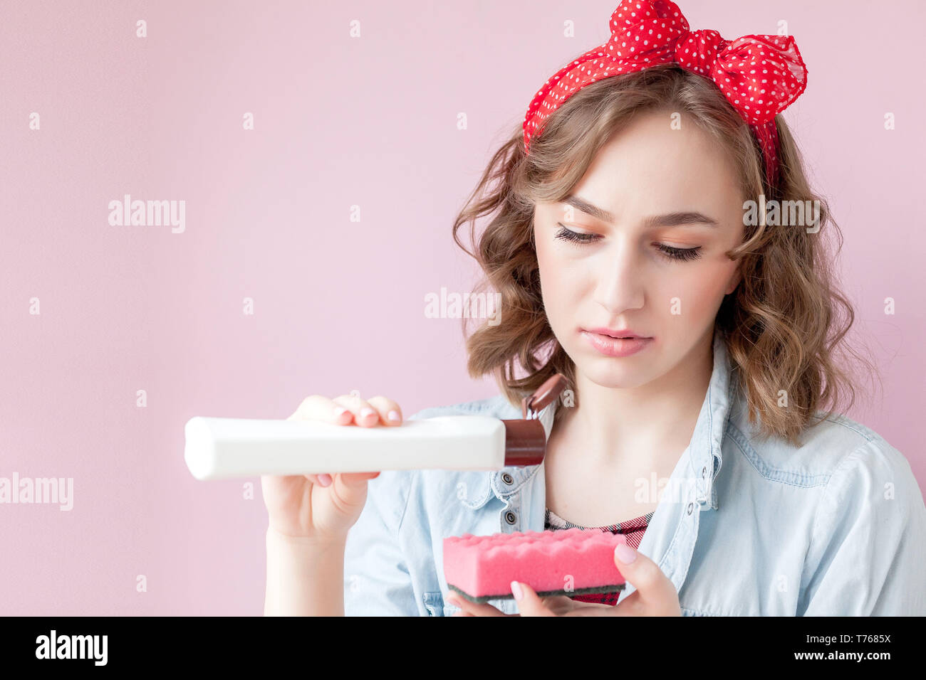 Beautiful young woman with pin-up make-up and hairstyle with cleaning ...