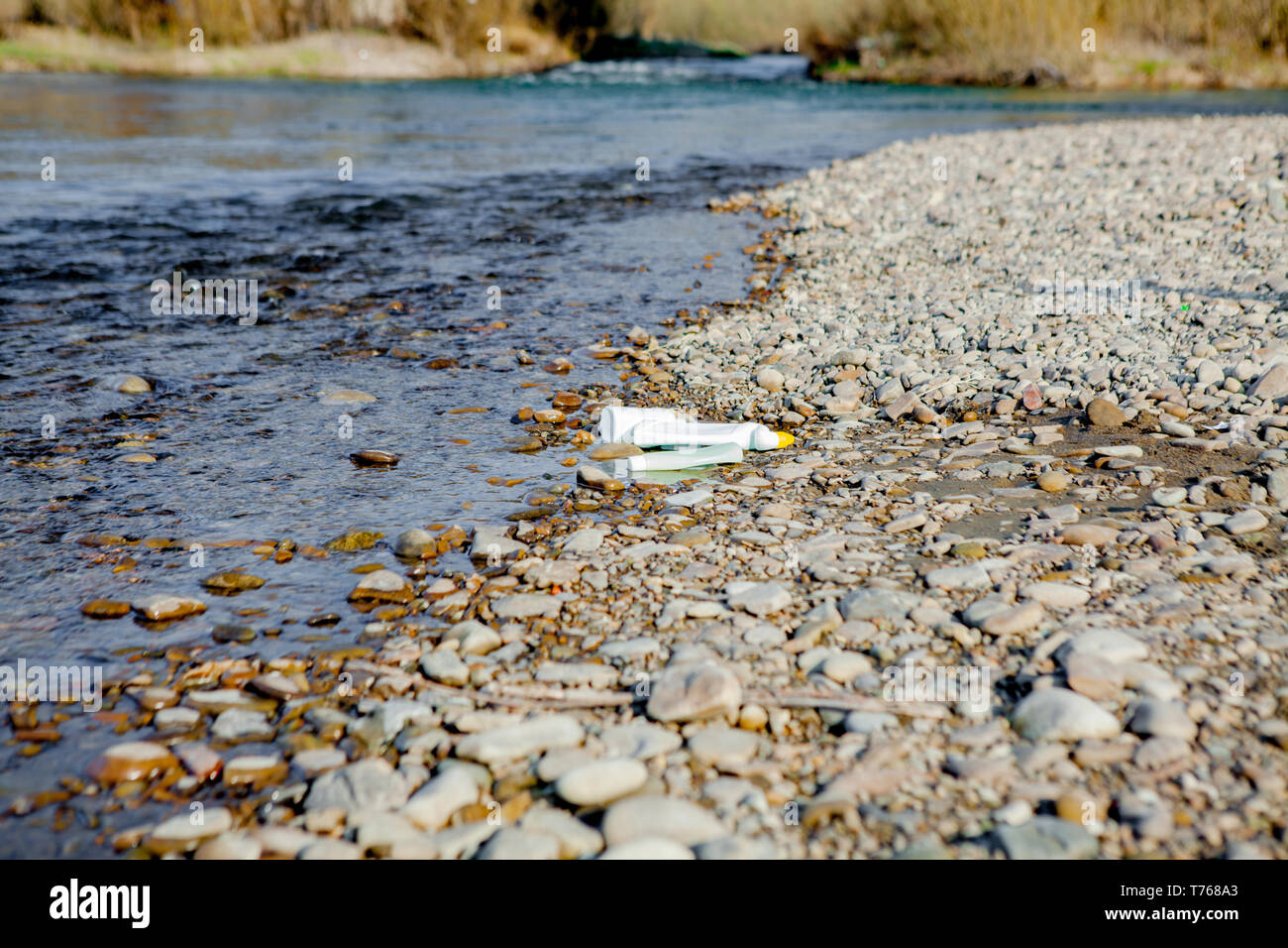 River pollution near the shore, garbage near the river, plastic food ...