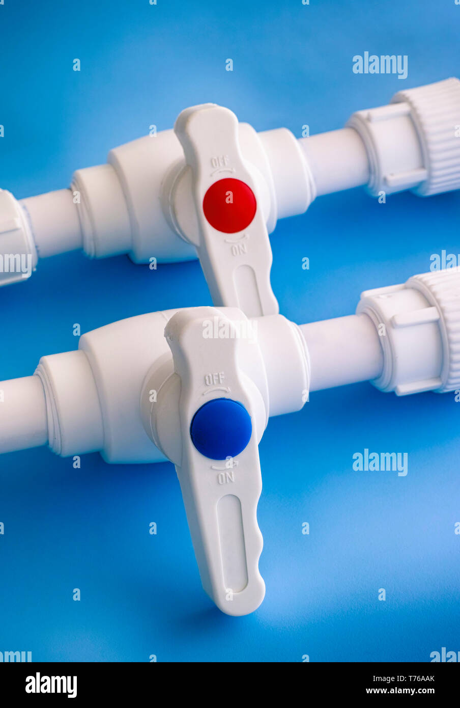Two pipes with switches on blue backgrounds. Close up Stock Photo - Alamy