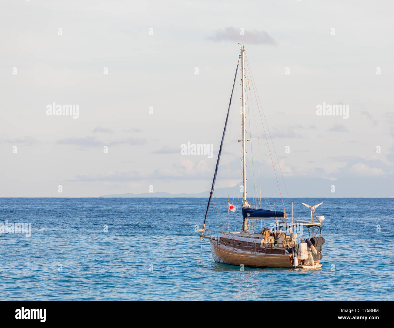 small sail boat at anchor off shell beach in St Barts Stock Photo - Alamy