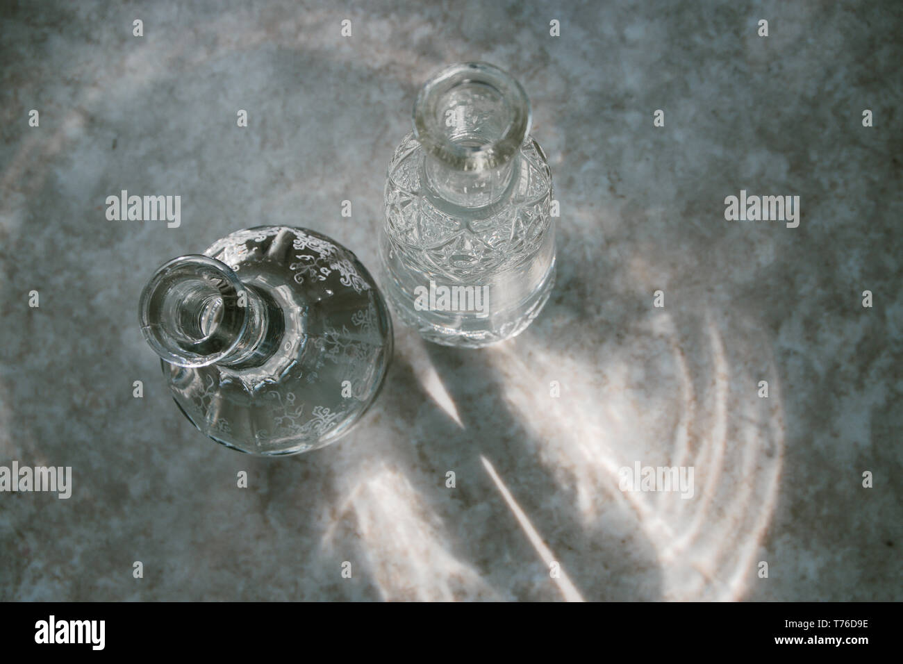 Vodka in two decanters on a marble surface top view light from the ...
