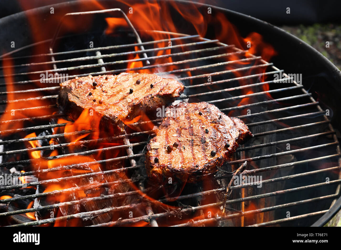 Delicious cooked meat on barbecue grill Stock Photo - Alamy