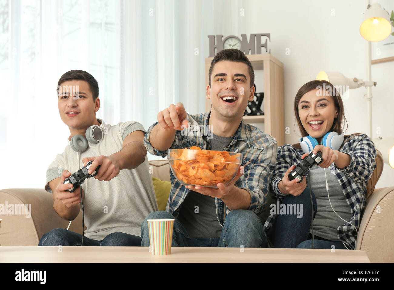 Young people playing video games at home Stock Photo - Alamy