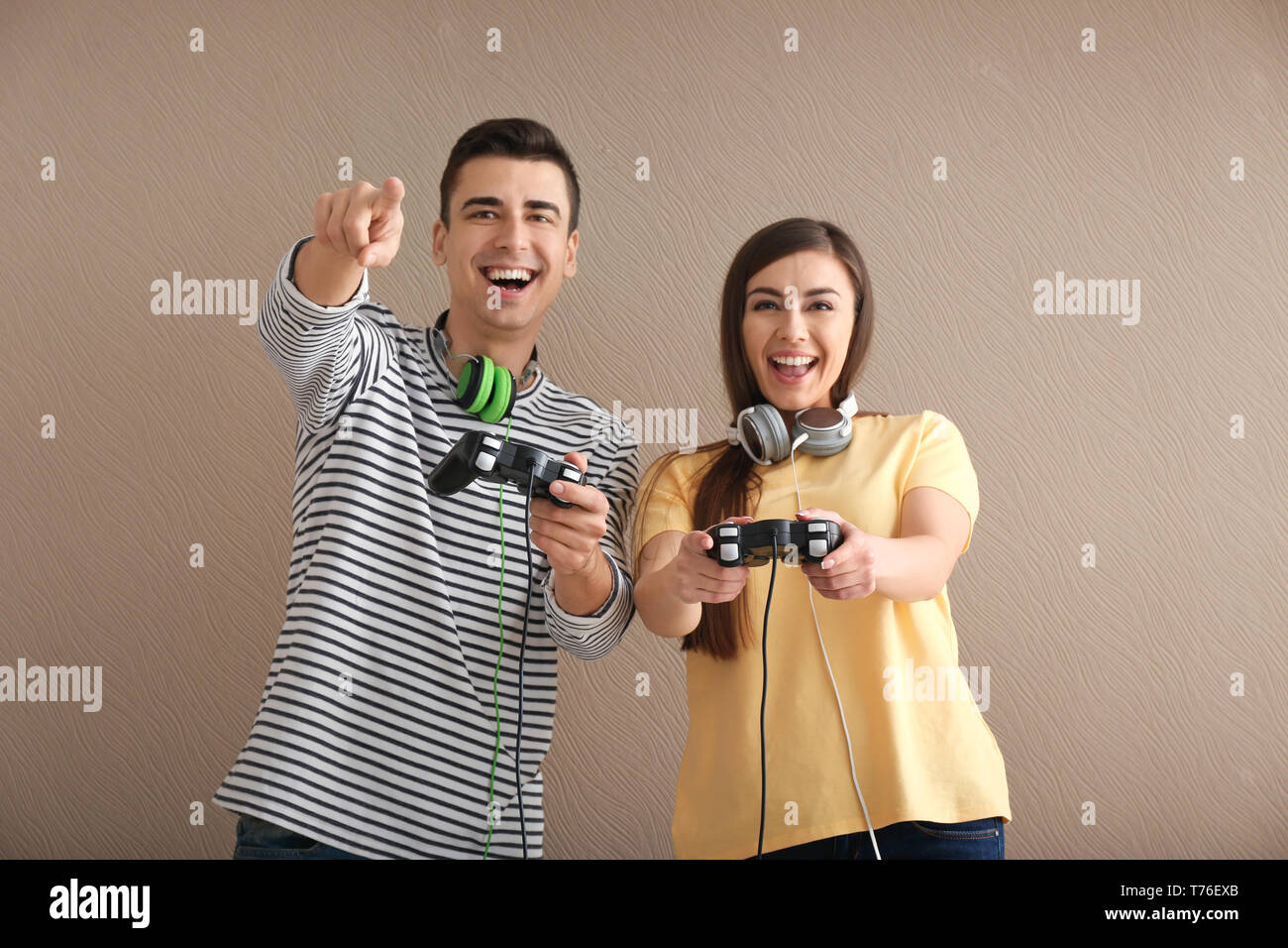 Young people with gamepads on color background Stock Photo - Alamy