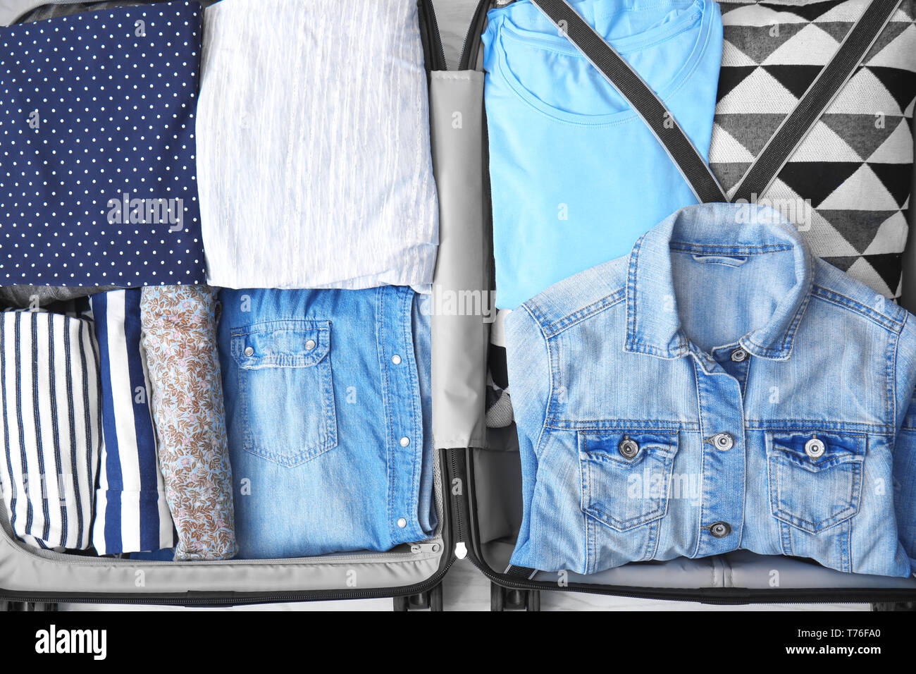 Folded clothes in open suitcase, top view Stock Photo - Alamy