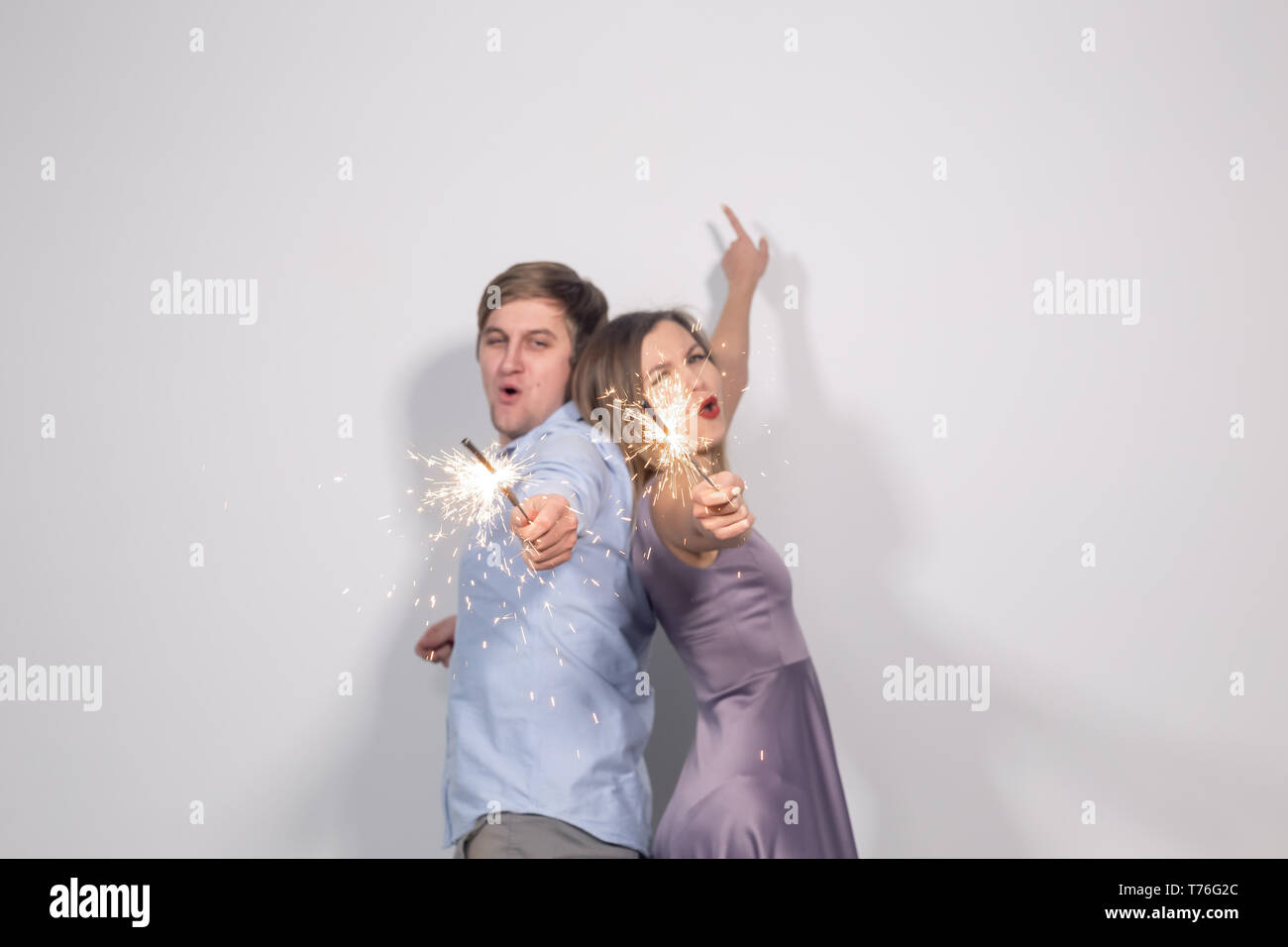 People, party and celebrations concept - young couple with sparklers ...