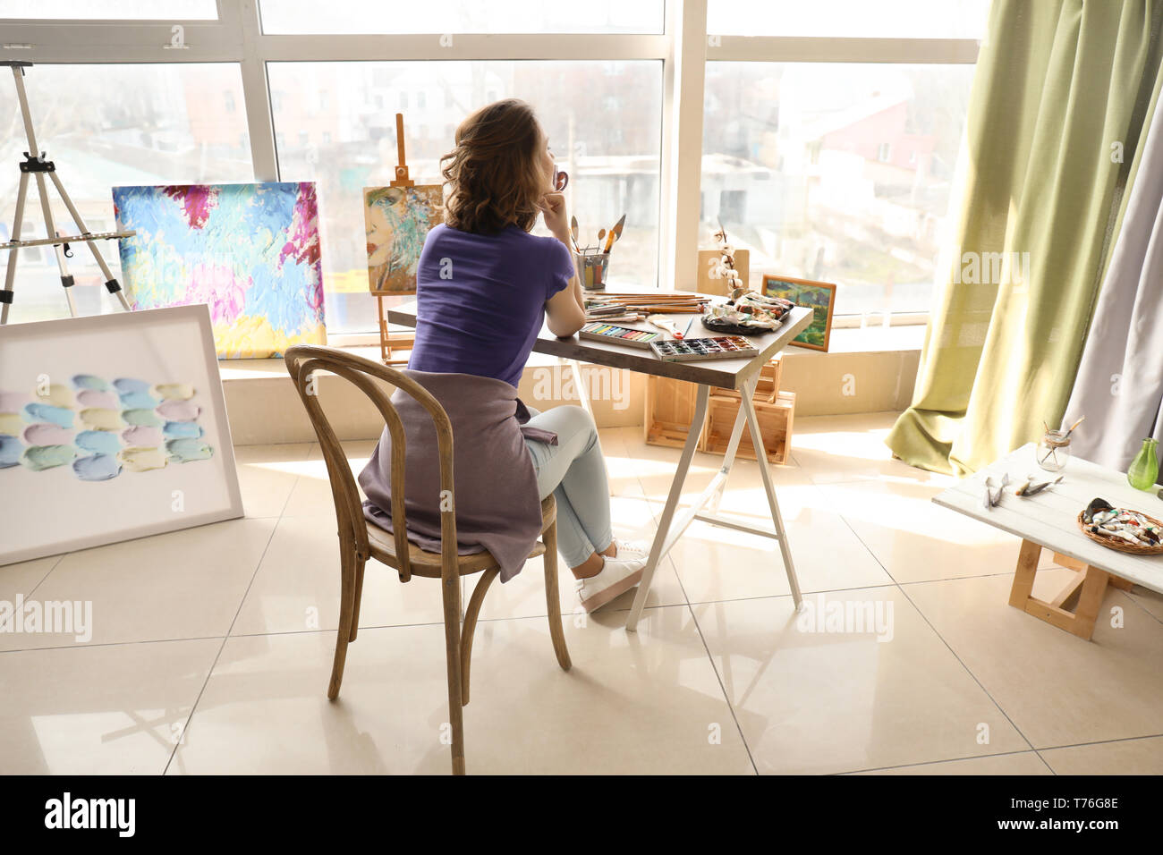Female artist drinking coffee in workshop Stock Photo - Alamy