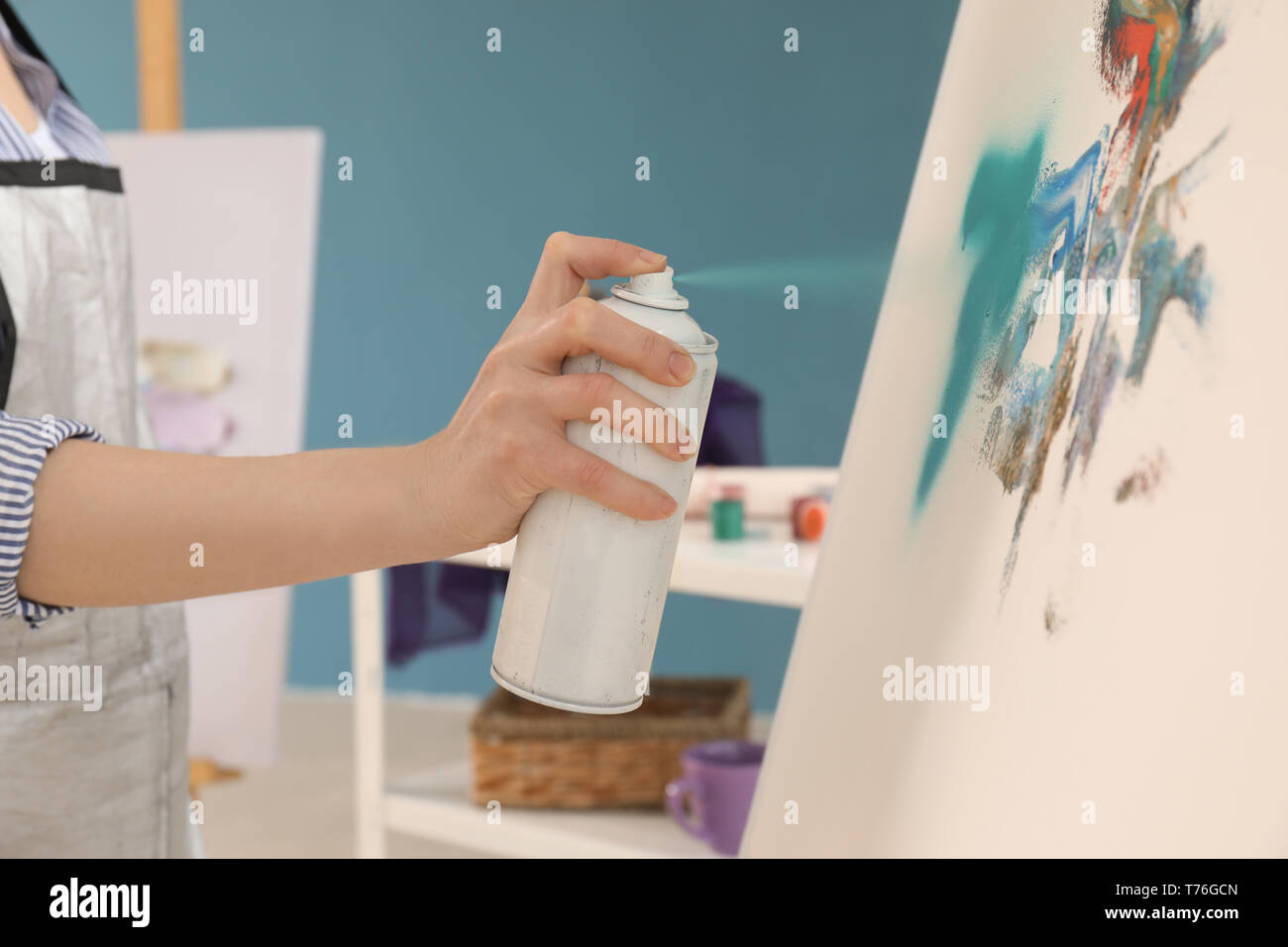 Female artist painting with aerosol spray in workshop Stock Photo - Alamy