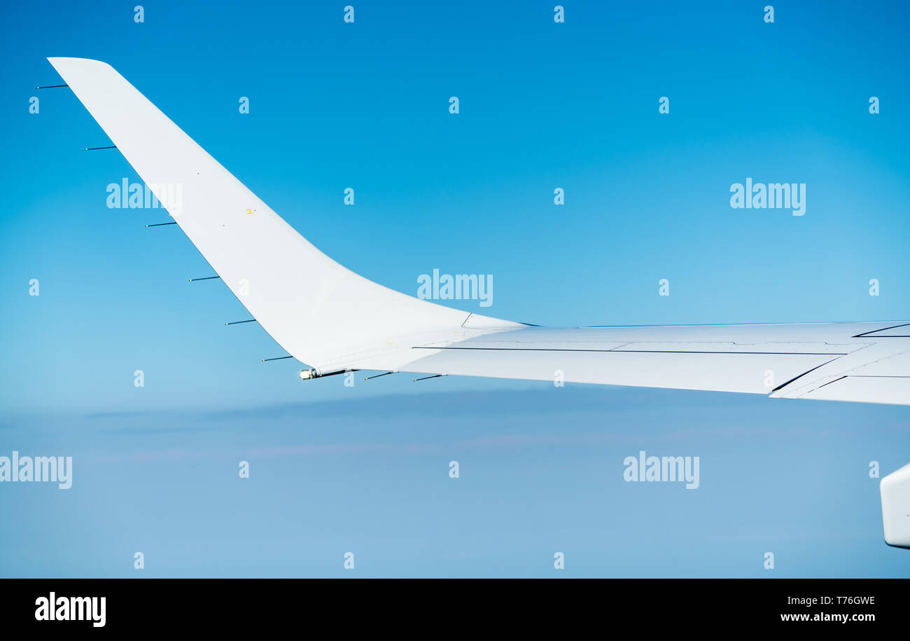 Wing of plane over white clouds. Airplane flying on blue sky. Scenic ...