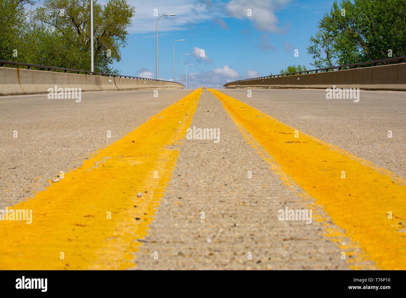 Open two lane road over a bridge with blue skies and clouds above Stock ...