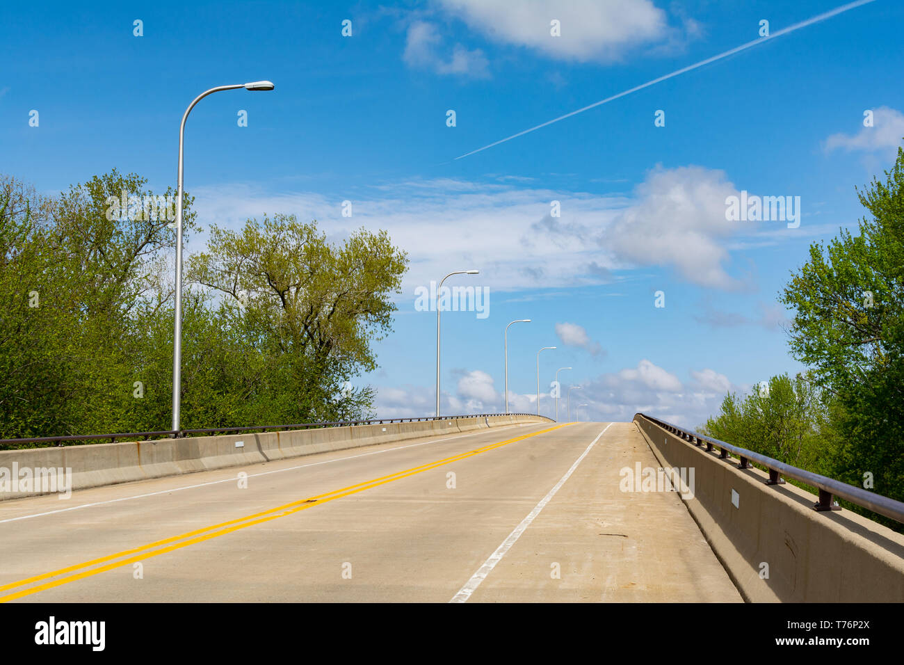 Open two lane road over a bridge with blue skies and clouds above Stock ...