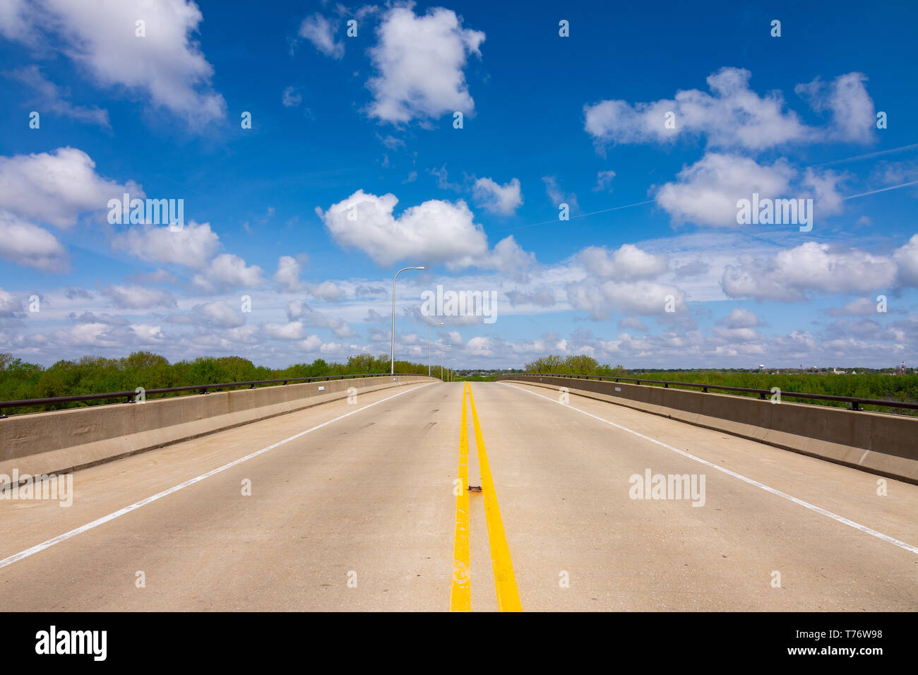 Open two lane road over a bridge with blue skies and clouds above Stock ...