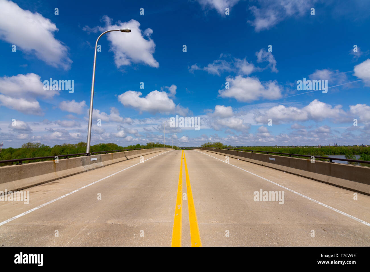 Open two lane road over a bridge with blue skies and clouds above Stock ...