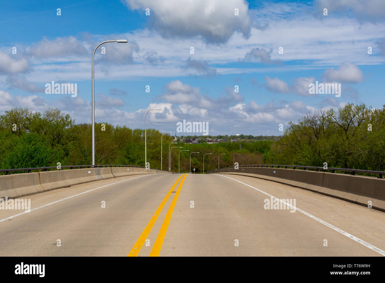 Open two lane road over a bridge with blue skies and clouds above Stock ...