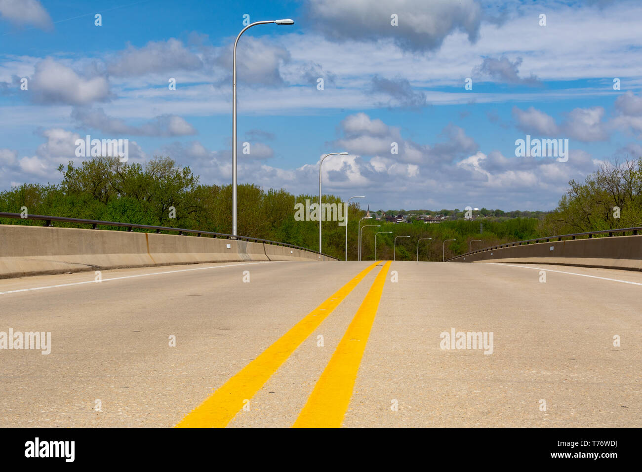 Open two lane road over a bridge with blue skies and clouds above Stock ...