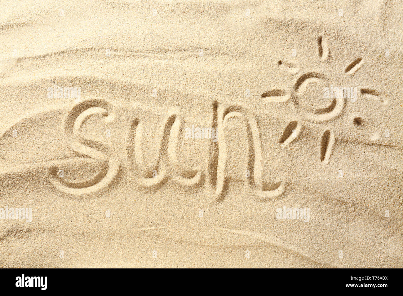 Word SUN written on beach sand Stock Photo - Alamy