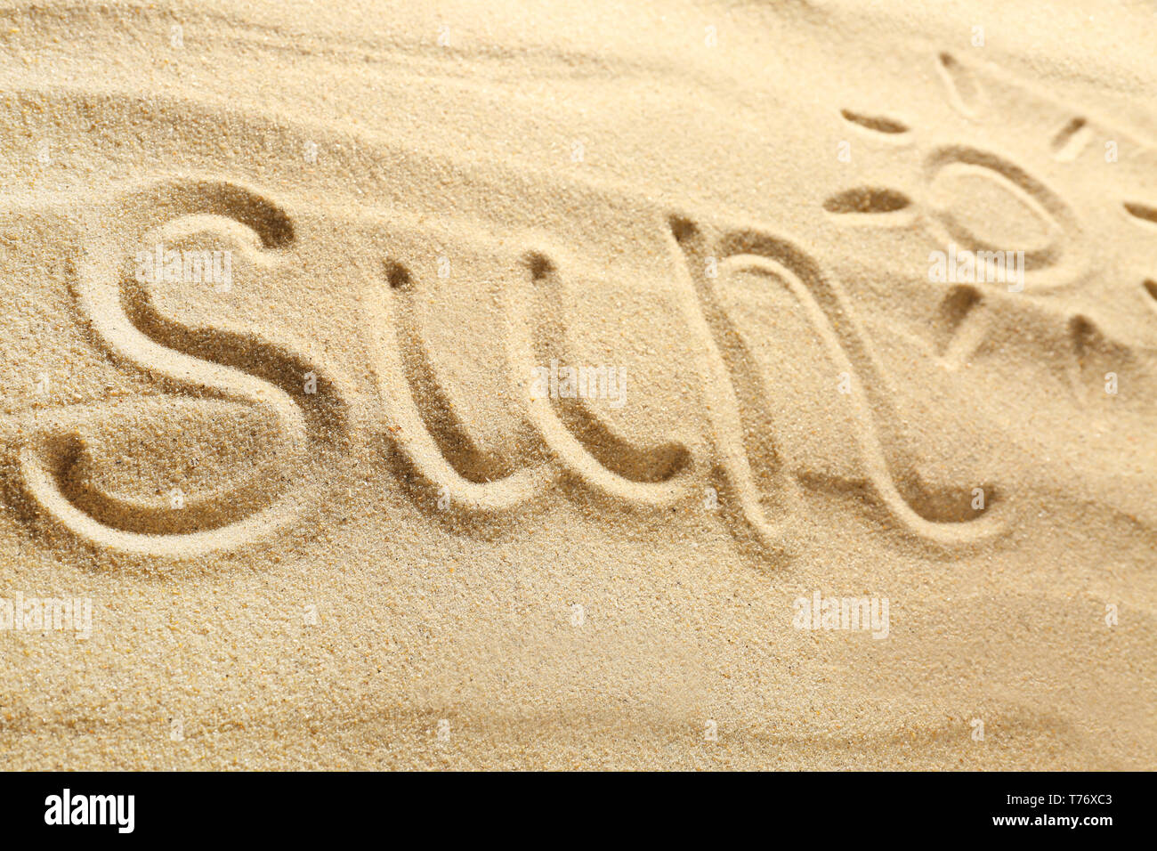 Word SUN written on beach sand Stock Photo - Alamy