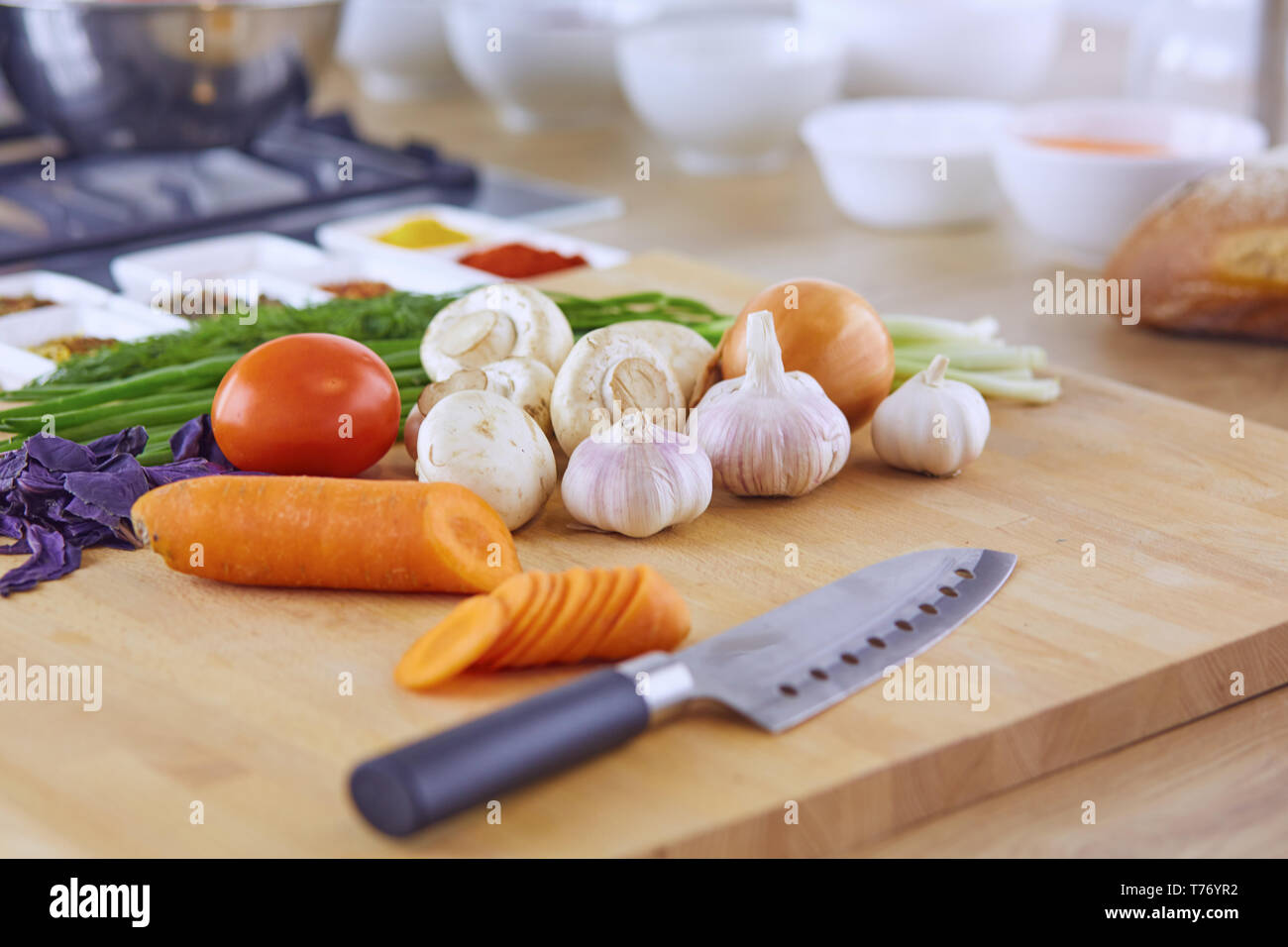 Composition with wooden board and ingredients for cooking on table ...