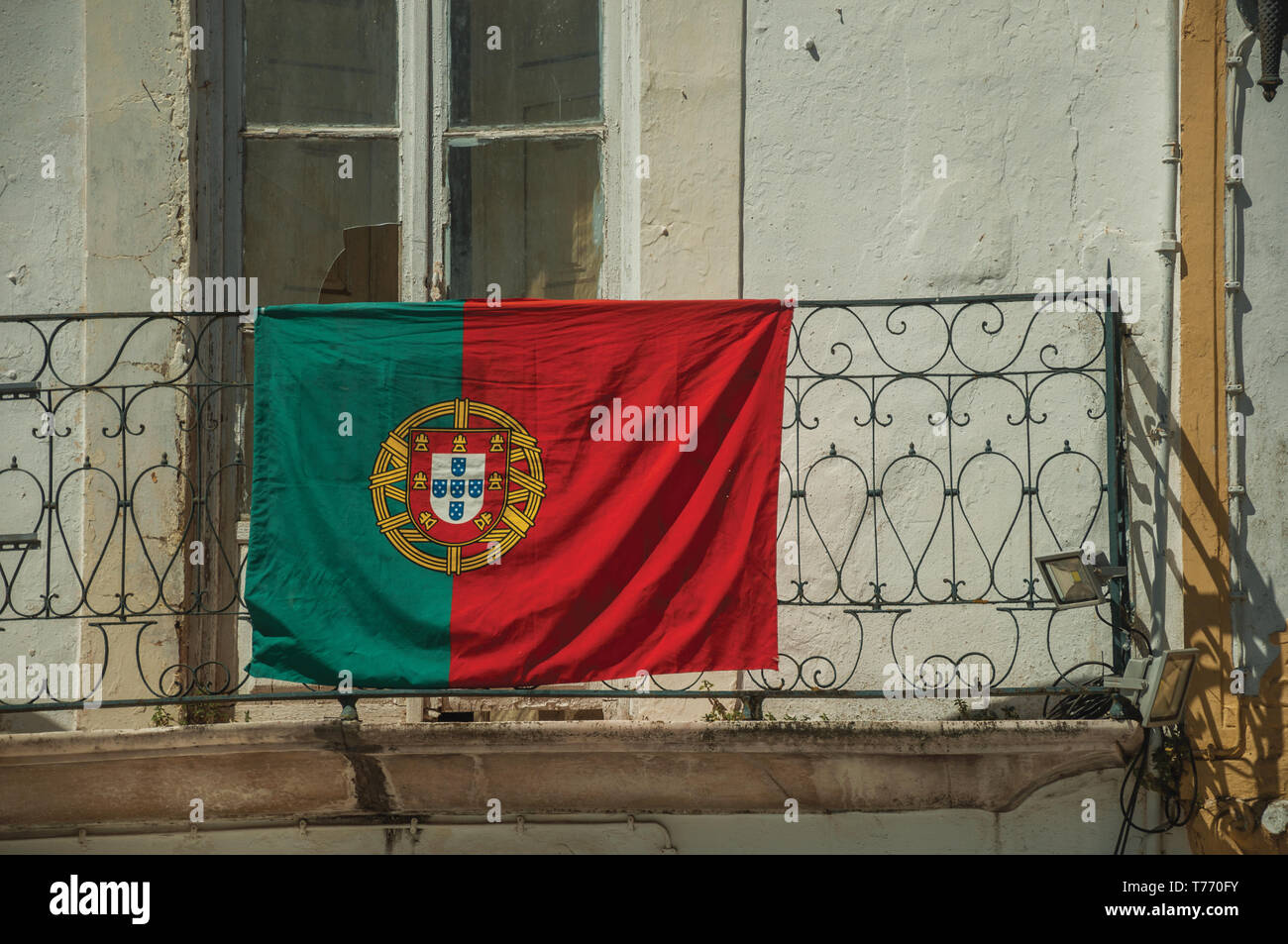 Portuguese flag on top of wrought iron handrail in an old building ...