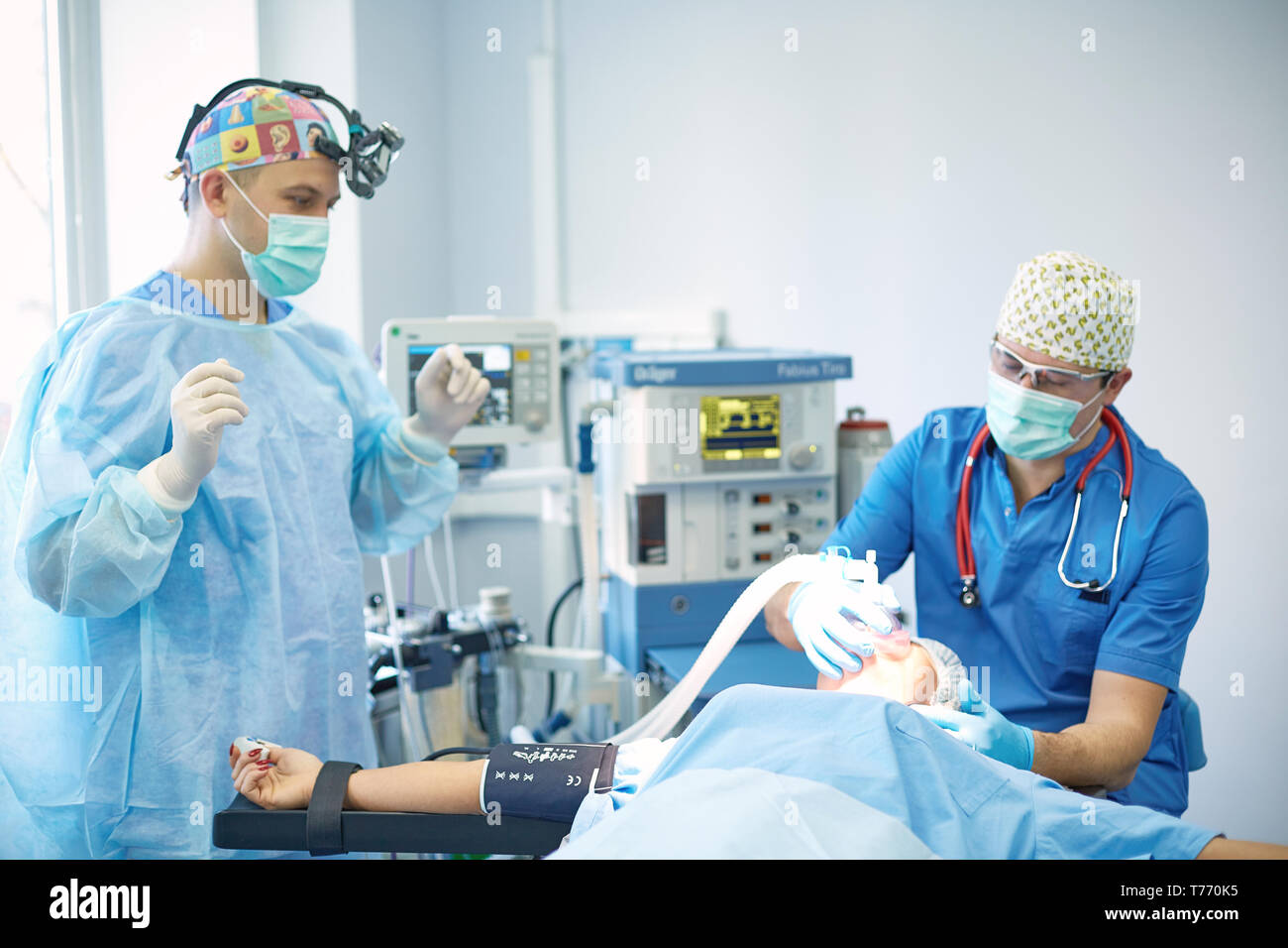 Several doctors surrounding patient on operation table during their ...