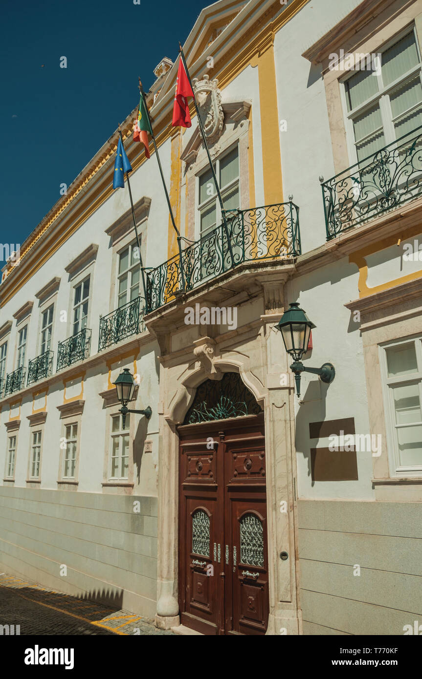 Building with wooden gate, windows with decorated iron balustrade and ...