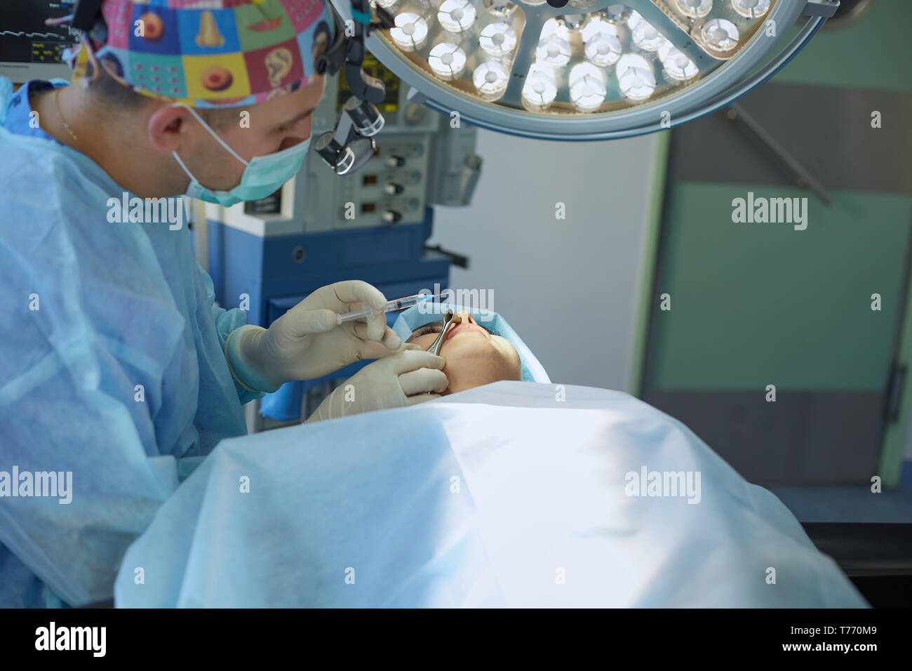 Several doctors surrounding patient on operation table during their ...