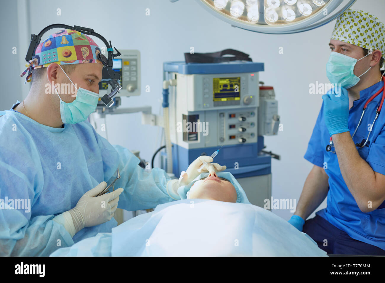 Several doctors surrounding patient on operation table during their ...