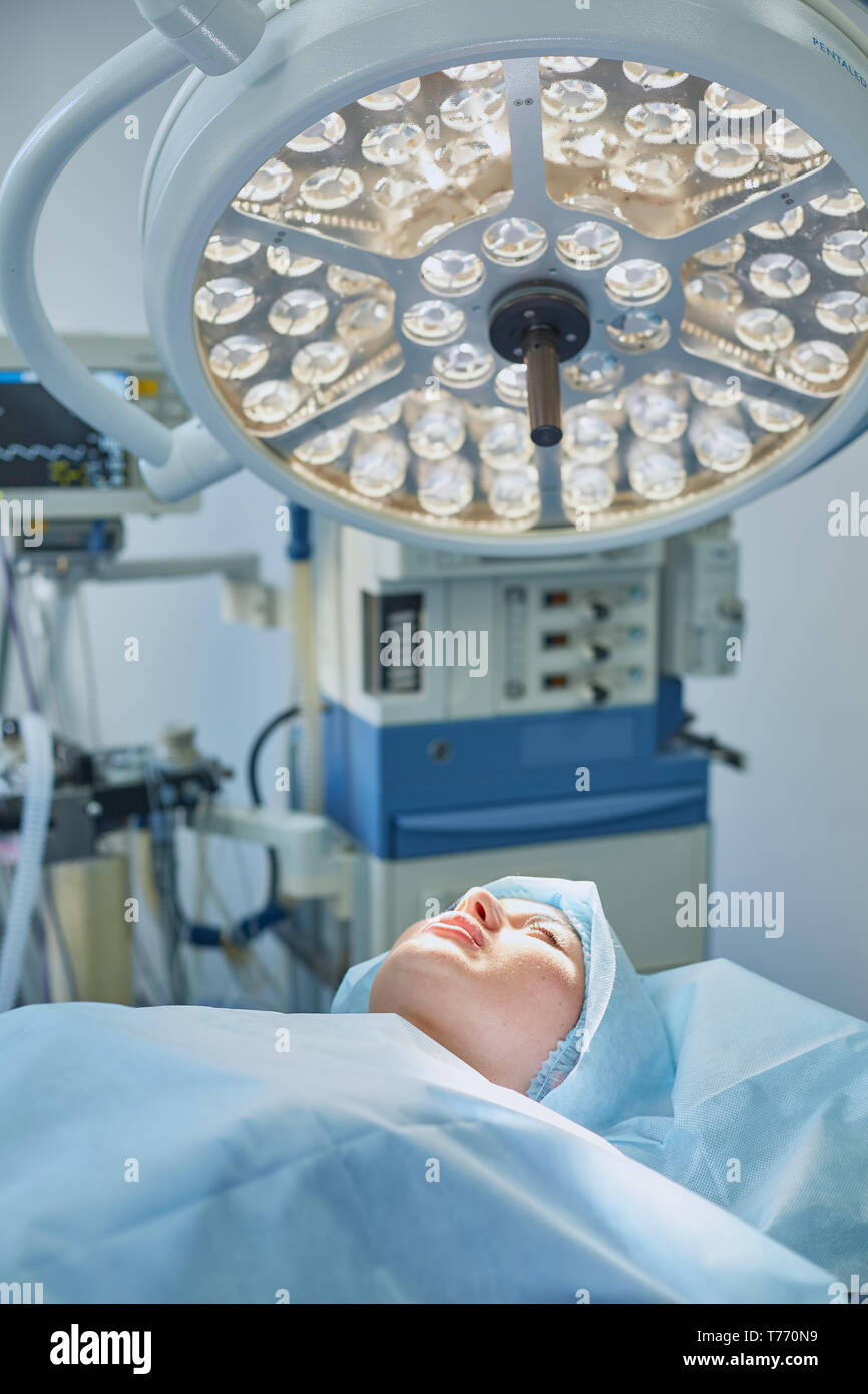 Several doctors surrounding patient on operation table during their ...