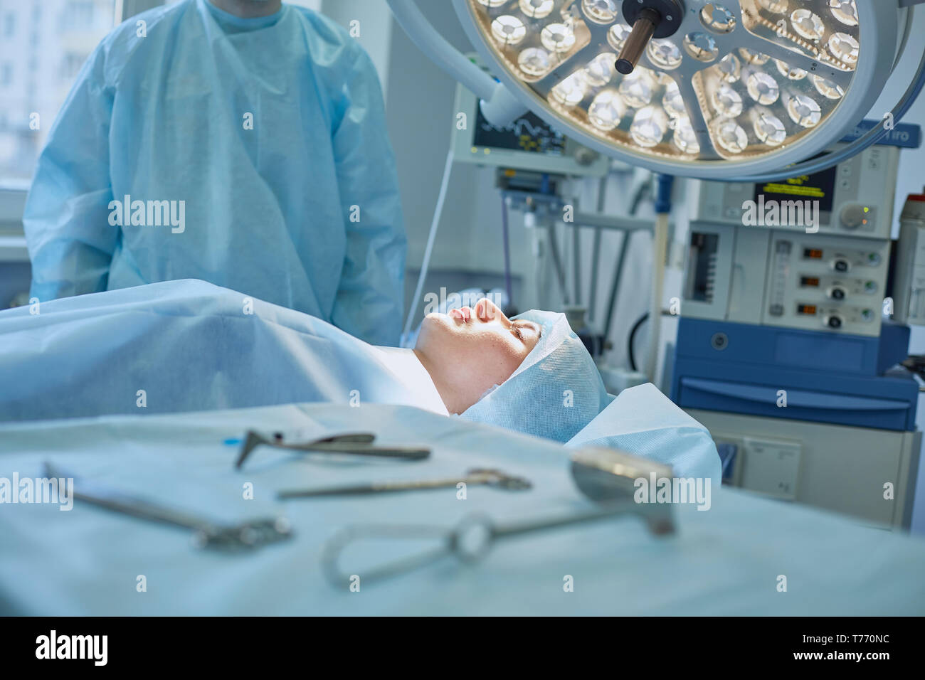 Several doctors surrounding patient on operation table during their ...