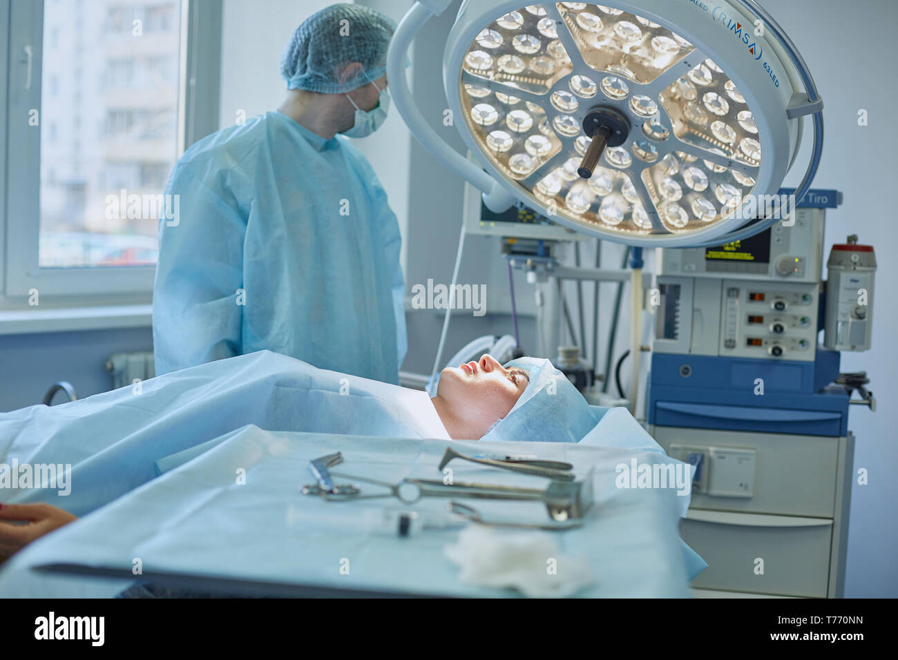 Several doctors surrounding patient on operation table during their ...