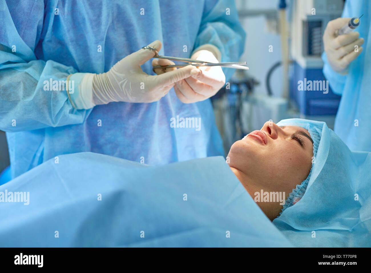 Several doctors surrounding patient on operation table during their ...