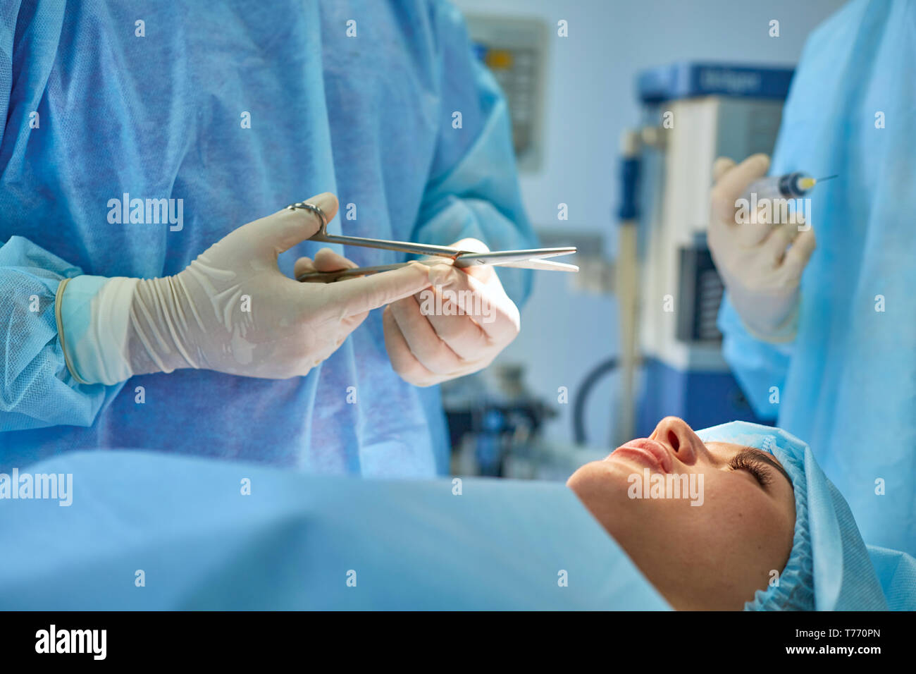 Several doctors surrounding patient on operation table during their ...