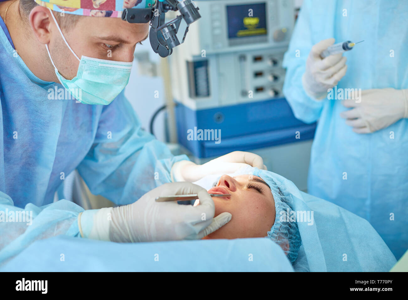 Several doctors surrounding patient on operation table during their ...