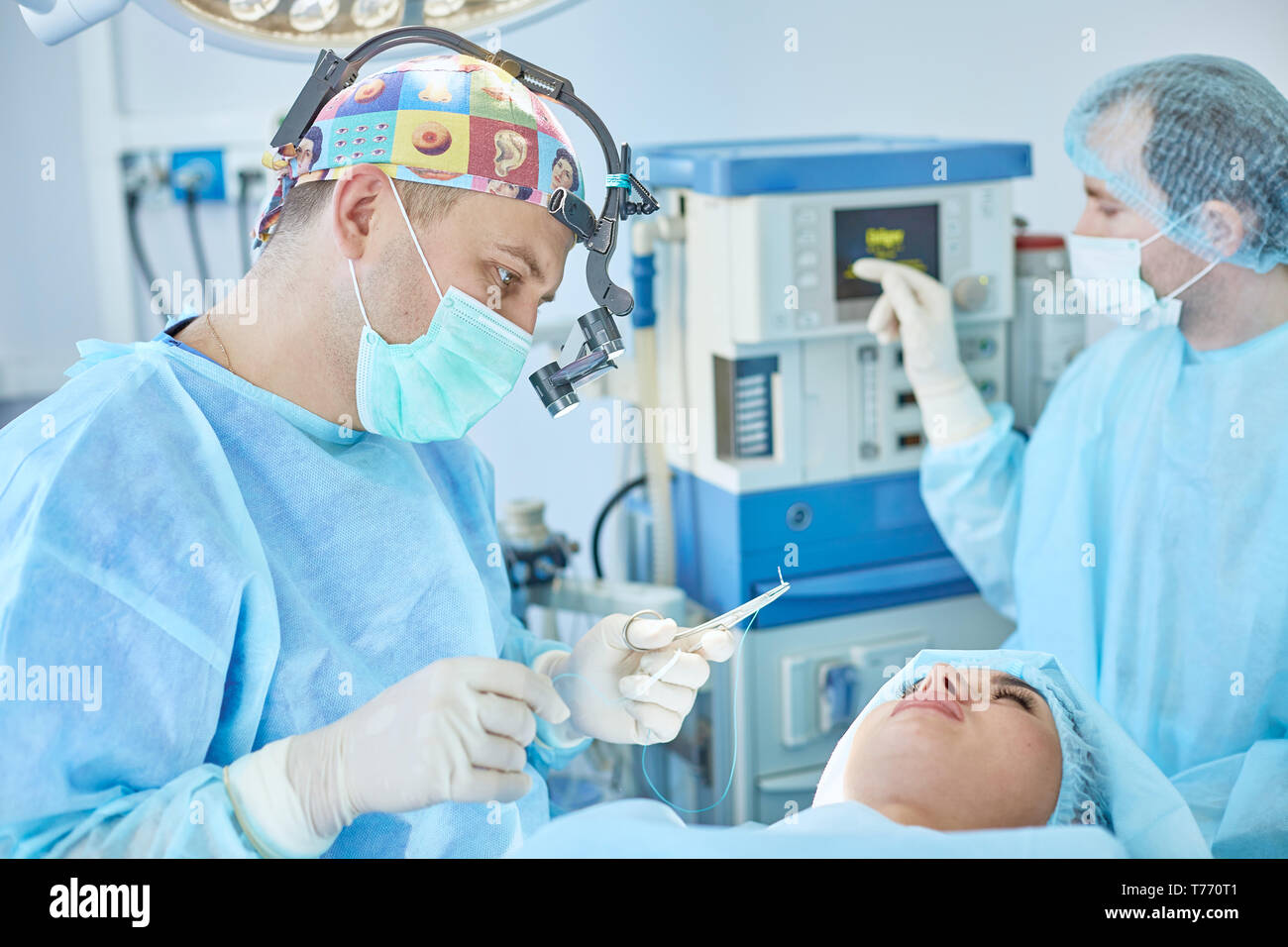 Several doctors surrounding patient on operation table during their ...