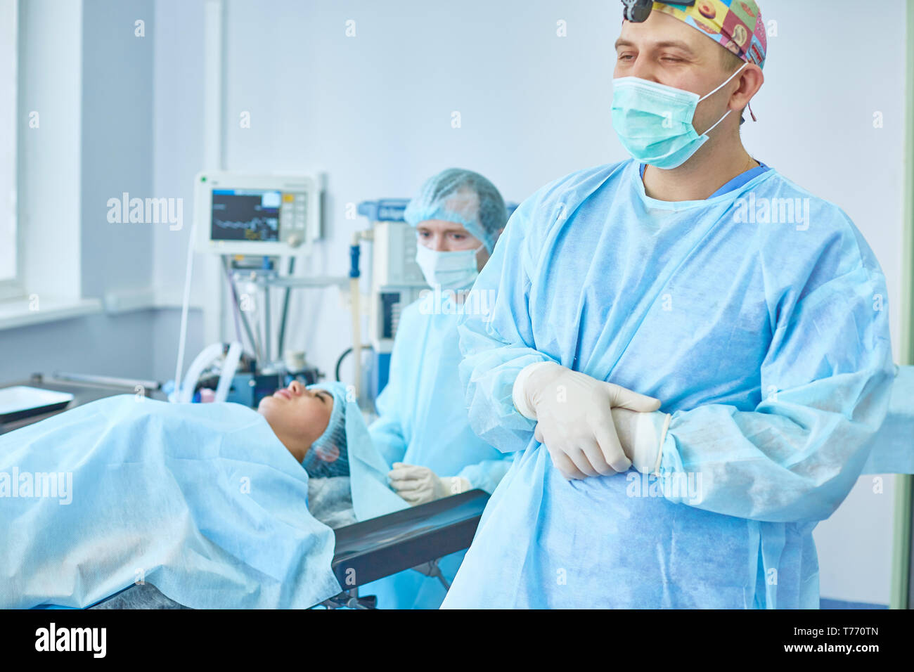 Several doctors surrounding patient on operation table during their ...