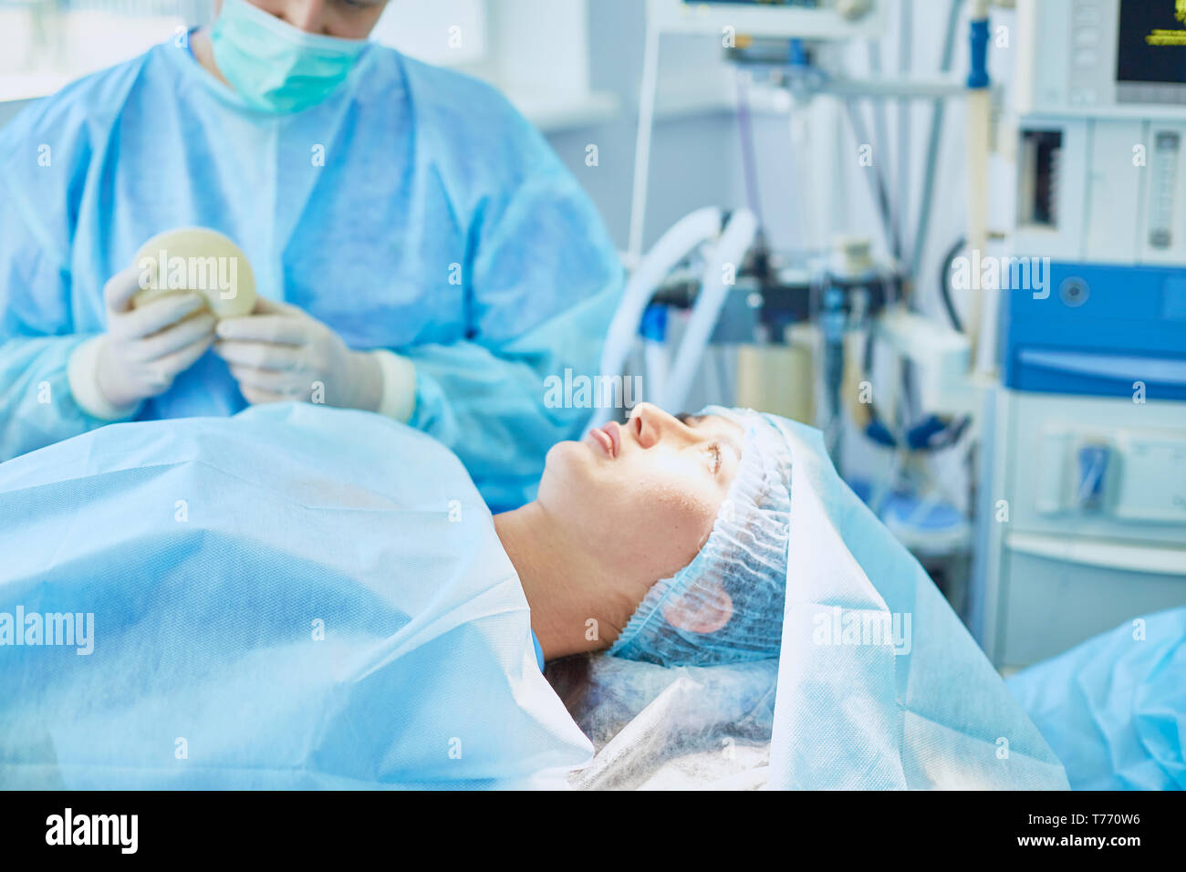 Several doctors surrounding patient on operation table during their ...