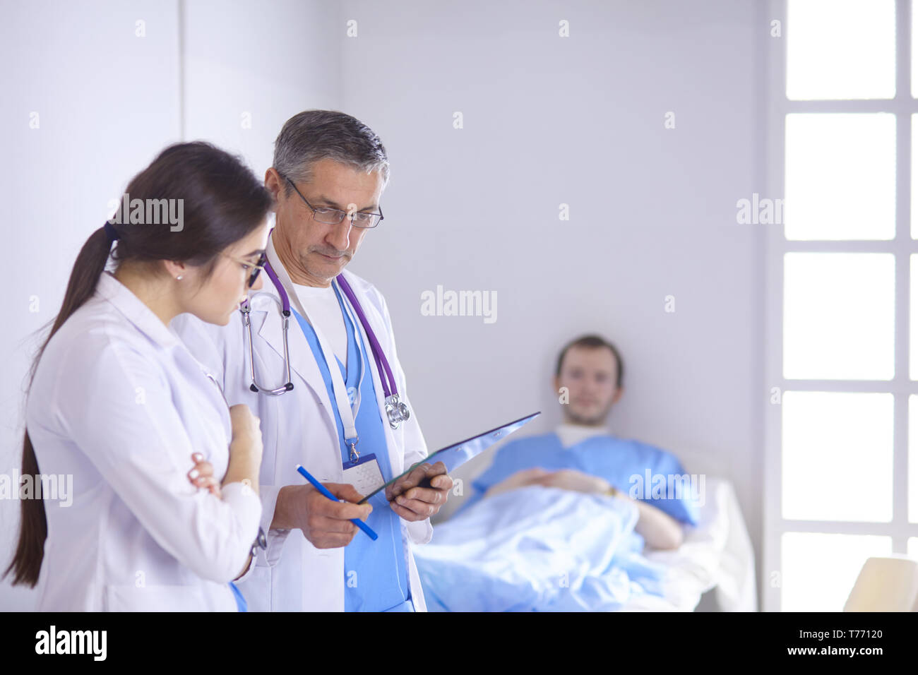 Doctor checking heart beat of patient in bed with stethoscope Stock ...