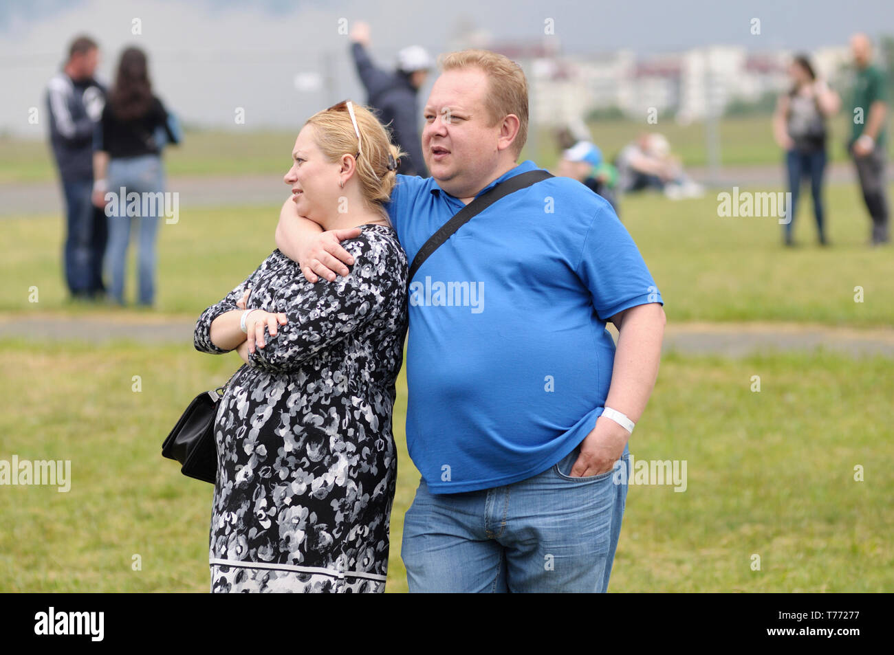 Pregnant woman standing on the lawn, at the city park, paunchy ...